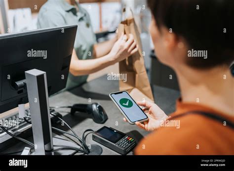 Female Customer Scanning Credit Card Reader While Paying Through Mobile Phone In Electronics