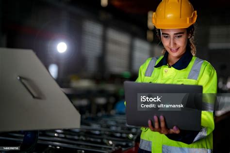 공장 엔지니어 브라질 여성이 노트북을 들고 자신 있게 서 있다 노동자는 산업 공장의 중장비에서 일합니다 기계 장비 플랜트 기술 똑똑한 산업 노동자 운영 개발에 대한 스톡