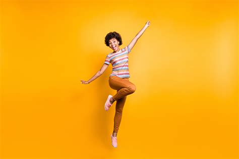 전체 길이 바디 사이즈 사진 의 쾌활 한 긍정적 인 펑키 황홀 한 소녀 에 오렌지 바지 줄무늬 티셔츠 신발 점프 고립 된 생생한 색상 배경 점프에 대한 스톡 사진 및 기타