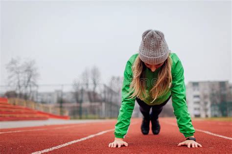 Young Woman In Sportswear Doing Plank Or Push Ups Outdoors On Winter
