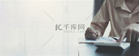 特写女商人使用计算器和笔记本电脑在办公室的木桌上做数学金融和商业工作背景税务会计统计和分析研究概念高清摄影大图 千库网