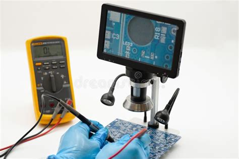 Technician Inspecting Circuit Board With Multimeter And Microscope Stock Image Image Of