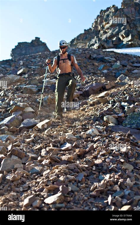 A Male Rockclimber Crosses A Scree Field Enroute To Some Alpine