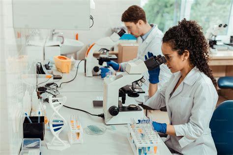 우리의 직장 현미경 앞에 앉아 있는 지능형 전문 생물학자들이 작업에 참여한다 사진 Unsplash의 과학적 연구 이미지