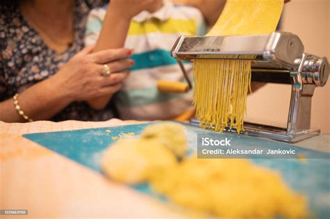 파스타 반죽이 들어오고 파스타 메이커에서 나오는 파스타 메이커와 할머니와 손자를 배경으로 만드는 2명에 대한 스톡 사진 및 기타 이미지 Istock