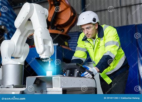 Man Engineer Using Remote Control Robot Arm Automate Robotic Automation In Line Production At
