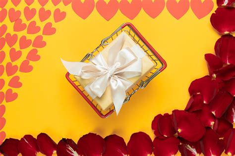 그것에 비문에 대 한 주황색 배경에 깜짝 선물 바구니거짓말 빨간 장미 꽃잎과 다른 크기의 종이 마음 발렌타인 데이 컨셉 0명에