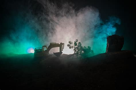 숲 삼림 벌채가 고 굴 삭 기 숲 제거 후 나무 젊고 아름 다운 여자와 뿌리를 발굴 하는 데 사용 어두운 톤의 안개 테이블 장식으로 개념 갈고리 발톱에 대한 스톡 사진 및