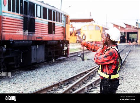 African Engineer Raised A Hand To Control A The Train On Railway With