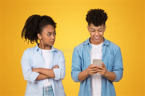 An African American Woman Skeptically Looks At A Young Man Who Is