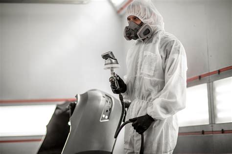 페인팅 부스의 자동차 부품에 페인트 코트를 적용 한 전체 작업복과 호흡 마스크의 차체 공장 기술자 가스 압축기에 대한 스톡 사진