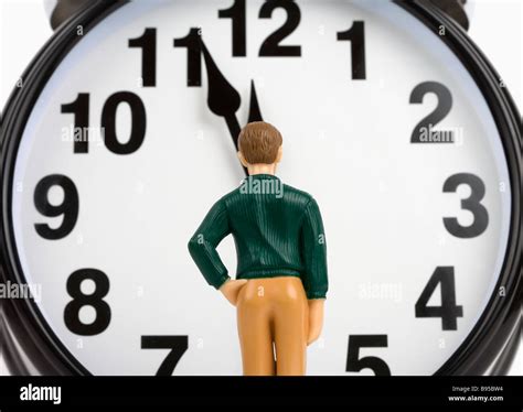 A Man Figurine Stares At A Clock Stock Photo Alamy