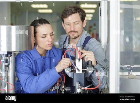 portrait of engineers using cad programming software at factory stock
