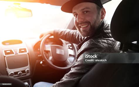 한 남자가 차를 몰고 간다 운전자는 도로를 따라 자동차로 운전하고 있습니다 태양은 바퀴의 운전자를 비시합니다 교통에 대한 스톡 사진 및 기타 이미지 Istock