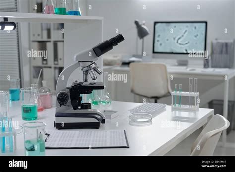 Modern Laboratory Setup Featuring High Tech Microscope And Various Chemical Solutions On