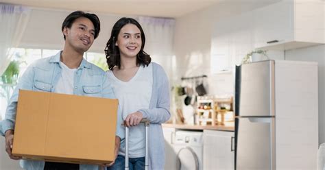 아시아의 젊은 행복한 새 결혼 부부가 함께 새 집으로 이사합니다 행복과 사랑으로 상자 소포와 여행 가방을 들고 매력적인 낭만적 인 남자와 여자 가족 이사 집 재배치 개념