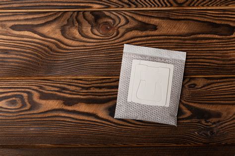 집에서 커피를 만드는 추세 갈색 배경에 커피 원두가 든 유리잔에 신선한 음료가 담긴 가방을 드립한다 컵에 양조하기위한 분쇄 커피 용지 필터를 사용하여 커피를 드립합니다