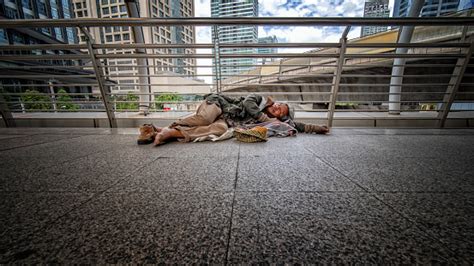 노숙자 남자 앞에 돈 기부에 대 한 오래 된 모자와 공공 경로 방식 층에 잠을 지 고 홈리스에 대한 스톡 사진 및 기타 이미지