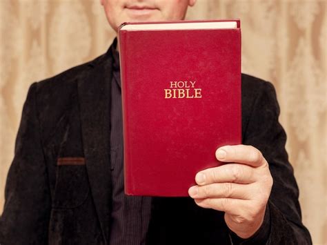 Un Hombre En Oración Con Una Biblia En La Mano Foto Premium