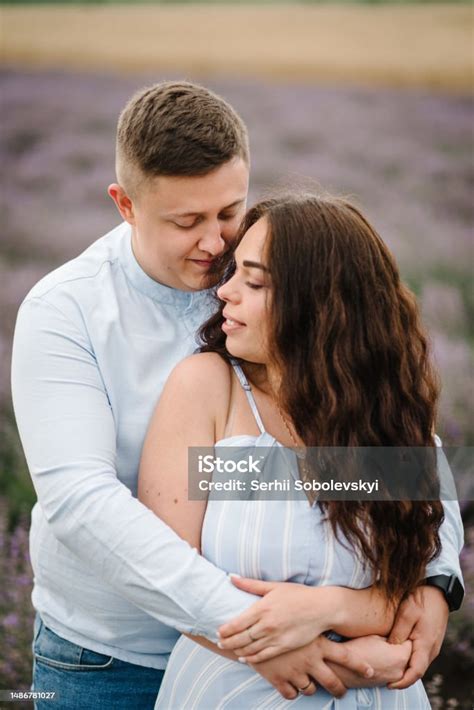남자와 여자는 서서 꽃 숲 사이의 빈터 여름의 자연을 즐긴다 해질녘에 걷는 사랑하는 커플 보라색 라벤더 꽃밭에서 포옹하는 가족 프랑스 프로방스 신혼 여행 여행 근접 촬영
