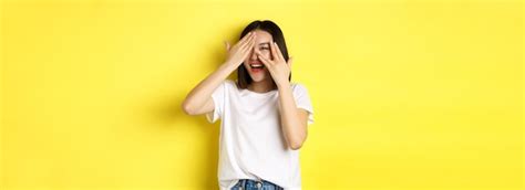Free Photo Intrigued Asian Girl Waiting For Surprise Peeking Through