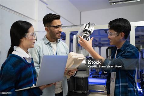 백인 남성 엔지니어서 노트북을 들고 아시아 여성 견습생 옆에 로봇 컨트롤러를 개최 아시아에 대한 스톡 사진 및 기타 이미지 아시아 아시아인 연수생 Istock