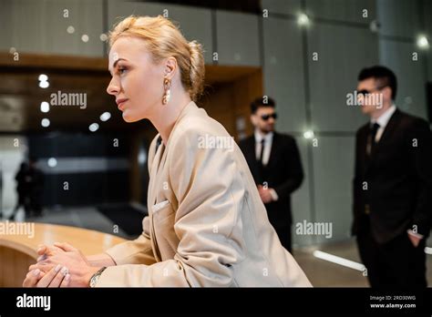 Blonde Woman In Suit Standing At Reception Desk Personal Security Service Concept Two