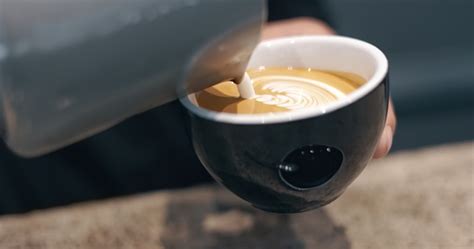 아침 클로즈업에서 식품 및 음료 산업에서 서비스를 위해 카페에서 커피 우유 및 컵 라떼 아트 거품 및 카페인 음료와 함께 바리 스타가 소규모 비즈니스 레스토랑에서 유제품을