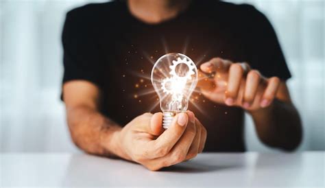 Premium Photo A Man Pointing At A Light Bulb With A Cogwheel On It