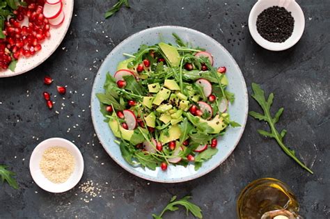 어두운 배경에 샐러드를 만들기위한 성분 접시에 야채 샐러드 아보카도 아루굴라 석류 무와 참깨 건강한 생활방식에 대한 스톡 사진 및 기타 이미지 Istock