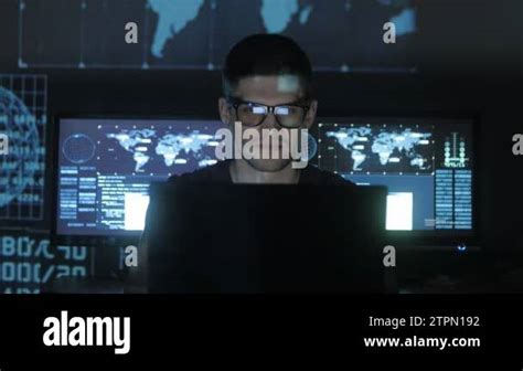hacker programmer in glasses is working on computer while blue binary