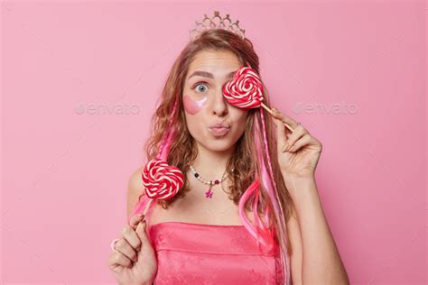 Lovely Surprised Woman Covers Eye With Sweet Tasty Candy Keeps Lips