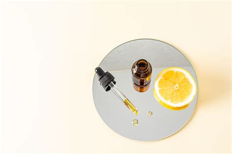 레몬 오일을 기본으로 한 화장품 천연 제품과 둥근 거울에 채워진 피펫이 있는 열린 병의 평면도 유기농 관리 생활필수품에 대한 스톡 사진 및 기타 이미지 Istock