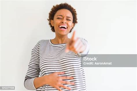 젊은 아름 다운 아프리카 계 미국인 여자 를 입고 줄무늬 스웨터 위에 흰색 배경 웃음 손가락 손으로 카메라를 가리키는 가슴 수치 표정 가리키기에 대한 스톡 사진 및 기타