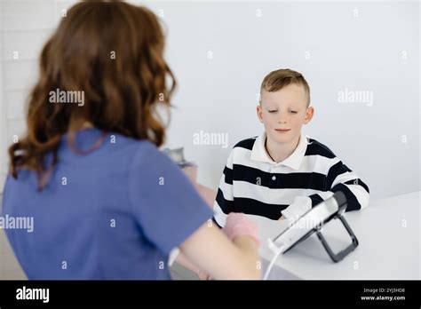 Boy Testing Breathing Function By Spirometry In Doctors Office