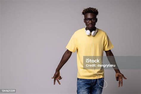 헤드폰과 휴대 전화와 젊은 매력적인 학생 남자 음악 춤을 듣고 노래 행복하고 흰색 배경에 재미 있는 흥분 사람들에 대한 스톡