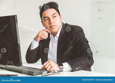 Young Office Worker Sitting At Desk Using Computer Two Business Man