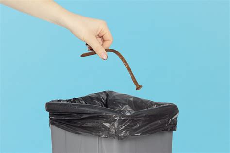 구부러진 못을 쓰레기통에 버리고 구부러지고 녹슨 못을 손에 들고 쓰레기통 앞에 버리고 금속 재활용 개념 개념에 대한 스톡 사진 및 기타 이미지 Istock