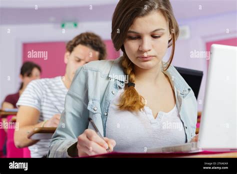 Female Babe Writing Notes In Class Stock Photo Alamy