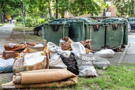 플라스틱 쓰레기통 근처 거리의 쓰레기에 던져 진 가정용 가구는 쓰레기와 쓰레기로 마을과 환경을 오염 쓰레기에 대한 스톡 사진 및