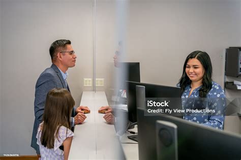 사무실 리셉션 데스크에서 체크인하는 라틴 아메리카 남성과 딸 은행 창구 직원에 대한 스톡 사진 및 기타 이미지 은행 창구