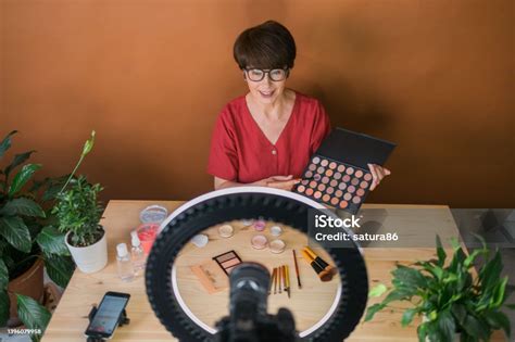 중년 여성 뷰티 블로거 또는 집에서 방에서 비디오를 녹화하는 메이크업 제품 인플루언서 링 램프 및 스마트폰 사용 55 59세에 대한 스톡 사진 및 기타 이미지 Istock