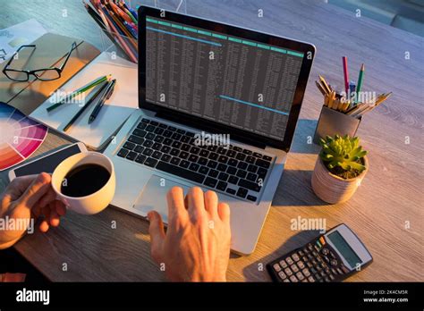 Hands Of Caucasian Male Programmer Sitting At Desk And Using Laptop With Coding On Screen