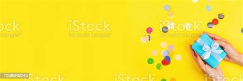 노란 배경에 선물 상자를 들고 있는 여성 핸드 상단 보기 플랫 레이 스타일 모의 템플릿 오버 헤드 생일 배경 8 행진 발렌타인 데이 결혼식 어머니의 날 아버지의 날 2월에