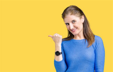 아름 다운 중 년의 성숙한 여자 생기고 엄지 측면 가리키는 행복 한 얼굴로 웃 고 고립 된 배경 위에 겨울 스웨터를 입고 가리키기에 대한 스톡 사진 및 기타 이미지 Istock