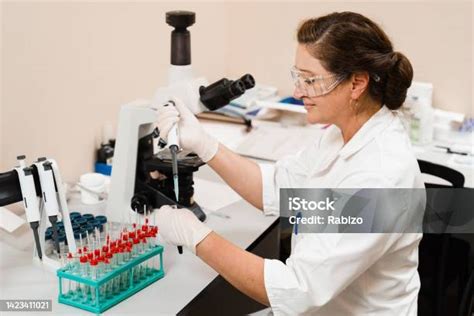 혈액 검사 분석을하는 실험실에서 마이크로 도저가있는 실험실 조수 실험실에서 의료 장비 혈액의 혈액학 분석을 수행하는 혈액 디스펜서를 가진 과학자 45 49세에 대한 스톡