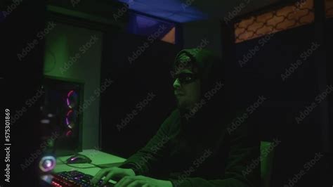 Black Glasses Wearing Evil Hacker Hacking Someone On Computer Looking At Monitors And