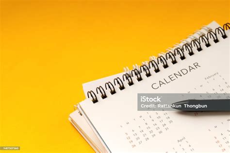 달력 달 일정은 약속 회의를 하거나 매일 시간표를 관리할 수 있도록 작업 및 여행 개념을 계획하기 위해 노란색 배경에 누워 펜을 놓습니다 0명에 대한 스톡 사진 및 기타