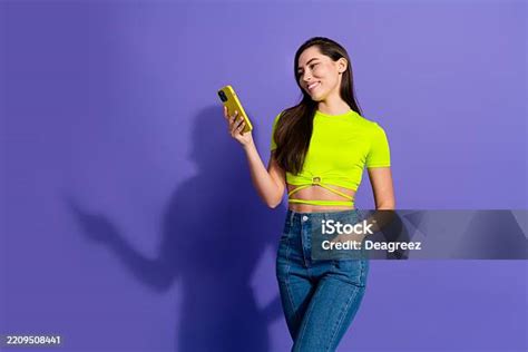 스마트 폰을 가진 미소 짓는 젊은 여자는 보라색 배경에 활기찬 옷을 입고 현대적인 라이프 스타일과 기쁨을 표현합니다 20 24세에 대한 스톡 사진 및 기타 이미지 Istock