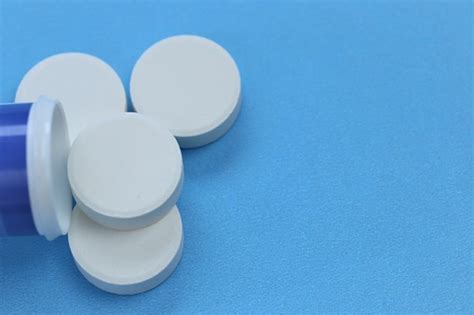 백색 알약 클로즈업 감기와 독감 바이러스 성 질병의 치료 및 예방 둥근 흰색 알약은 파란색 배경에 클로즈업 의학 및 건강 개념 약물 및 처방약 0명에 대한 스톡 사진 및